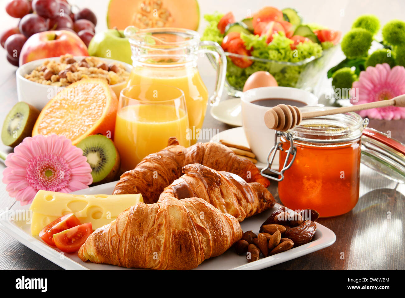 Breakfast consisting of fruits, orange juice, coffee, honey, bread and ...
