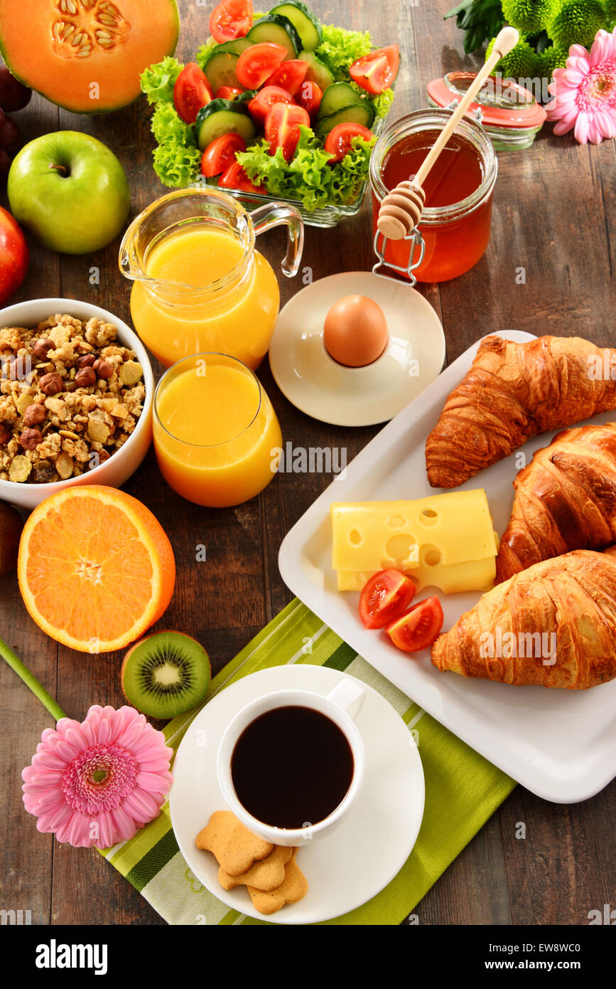 Breakfast consisting of fruits, orange juice, coffee, honey, bread and ...