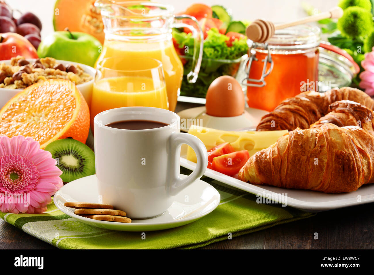 Breakfast consisting of fruits, orange juice, coffee, honey, bread and ...