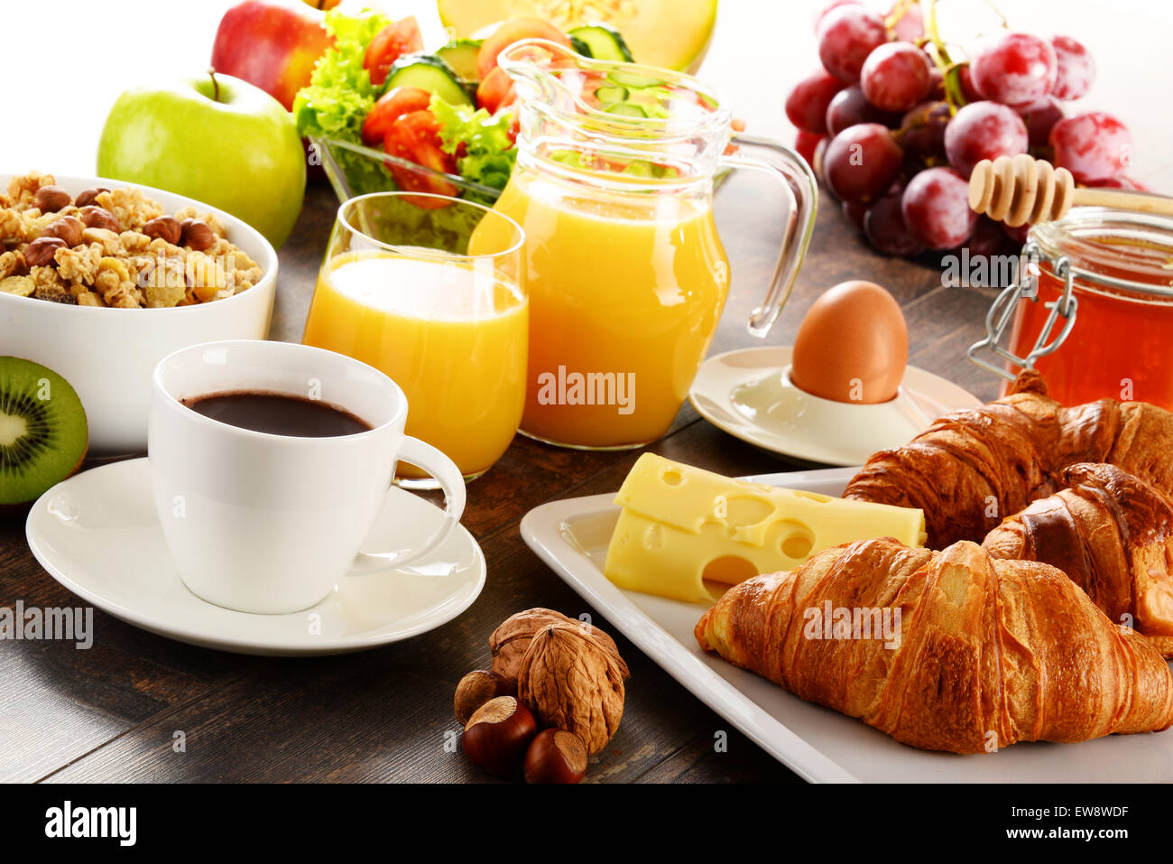 Breakfast consisting of fruits, orange juice, coffee, honey, bread and ...