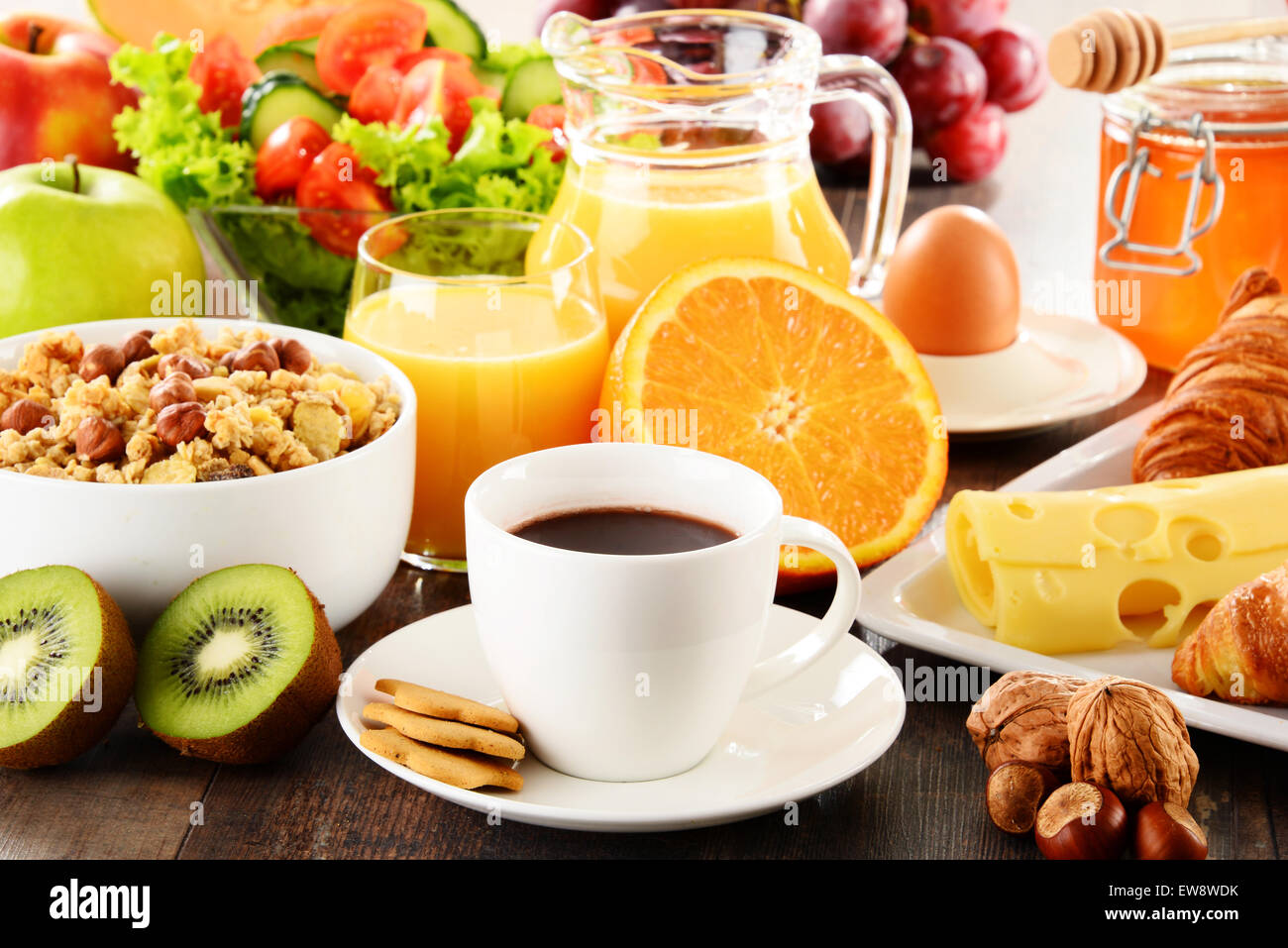 Breakfast consisting of fruits, orange juice, coffee, honey, bread and ...