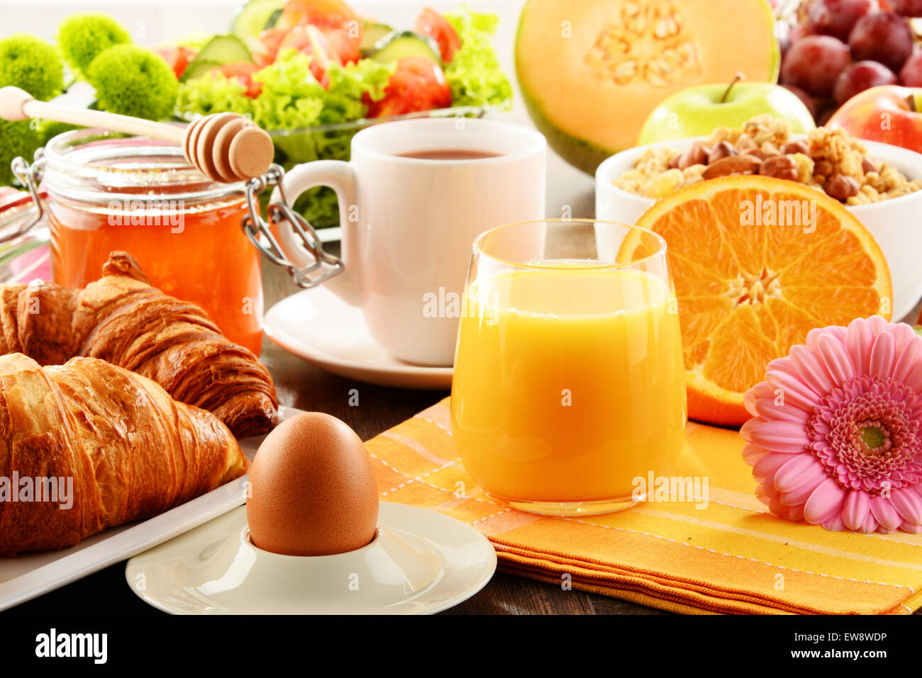 Breakfast consisting of fruits, orange juice, coffee, honey, bread and ...