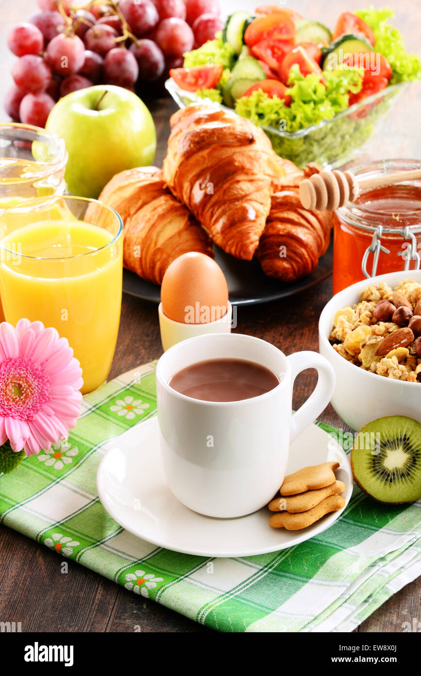 Breakfast consisting of fruits, orange juice, coffee, honey, bread and ...