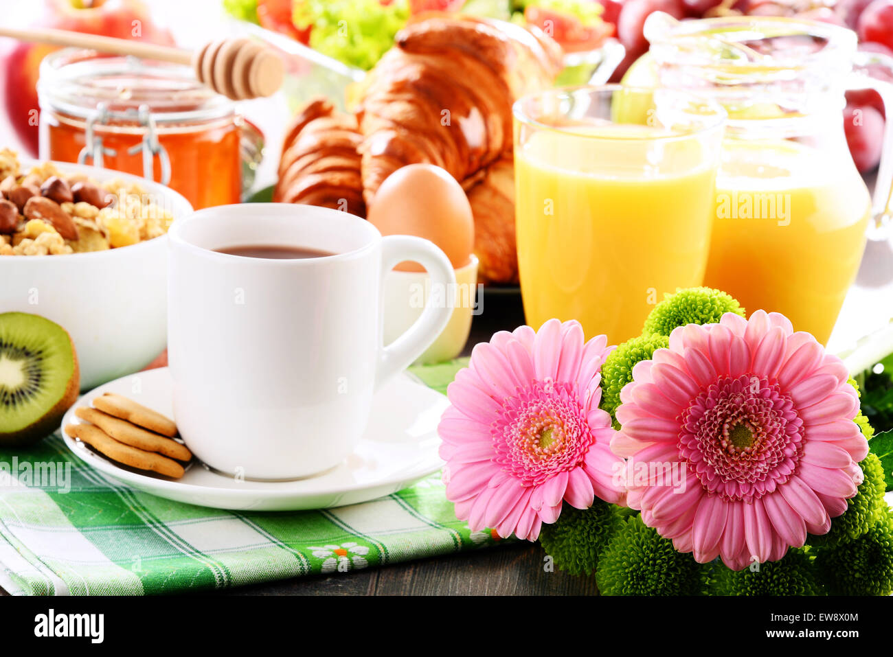 Breakfast consisting of fruits, orange juice, coffee, honey, bread and ...