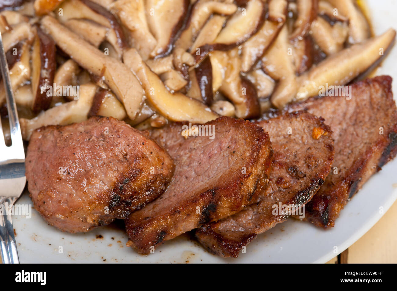 venison deer game filet tenderloin and fresh wild mushrooms Stock Photo ...