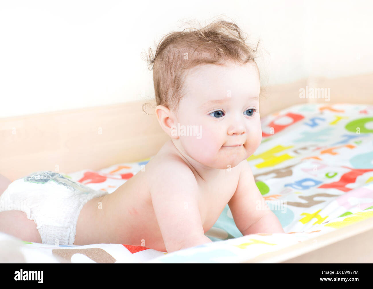 Cute little baby playing in a bed wearing a diaper Stock Photo - Alamy