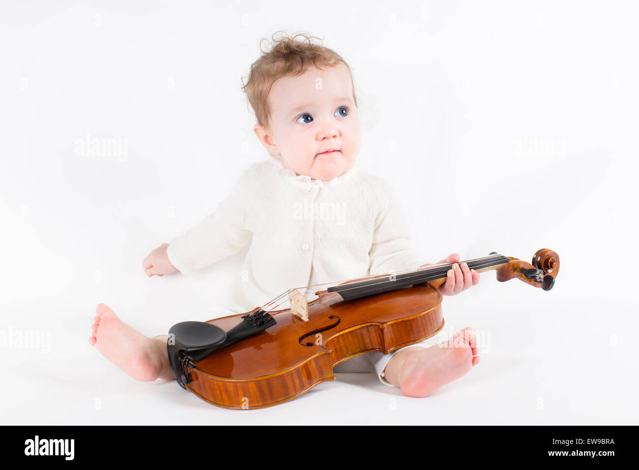 Beautiful baby girl playing with a violin Stock Photo - Alamy