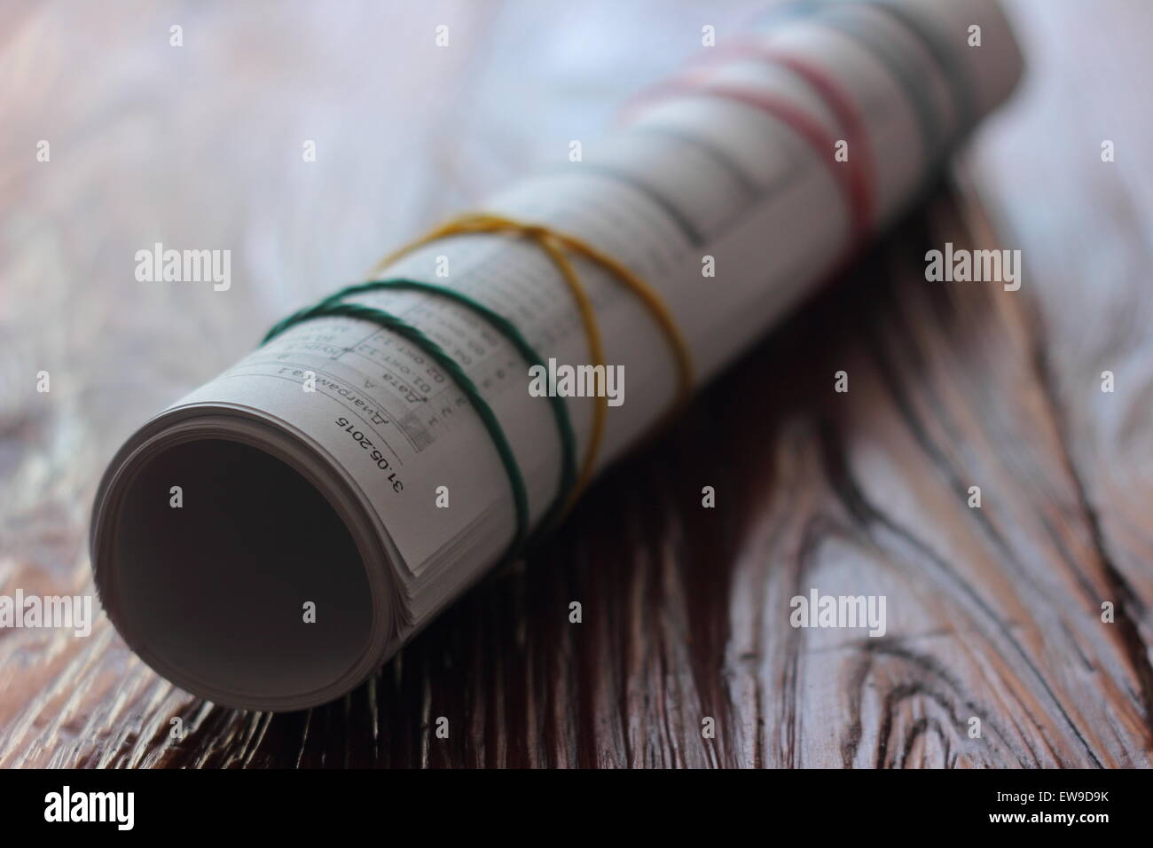 Financial paper rolled into a tube with rubber bands Stock Photo - Alamy
