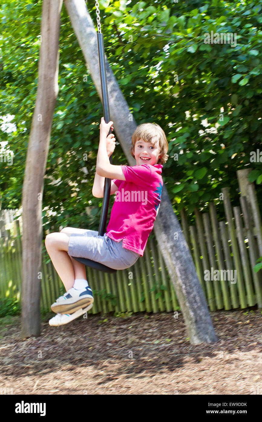 Boy playing on a swing Stock Photo - Alamy