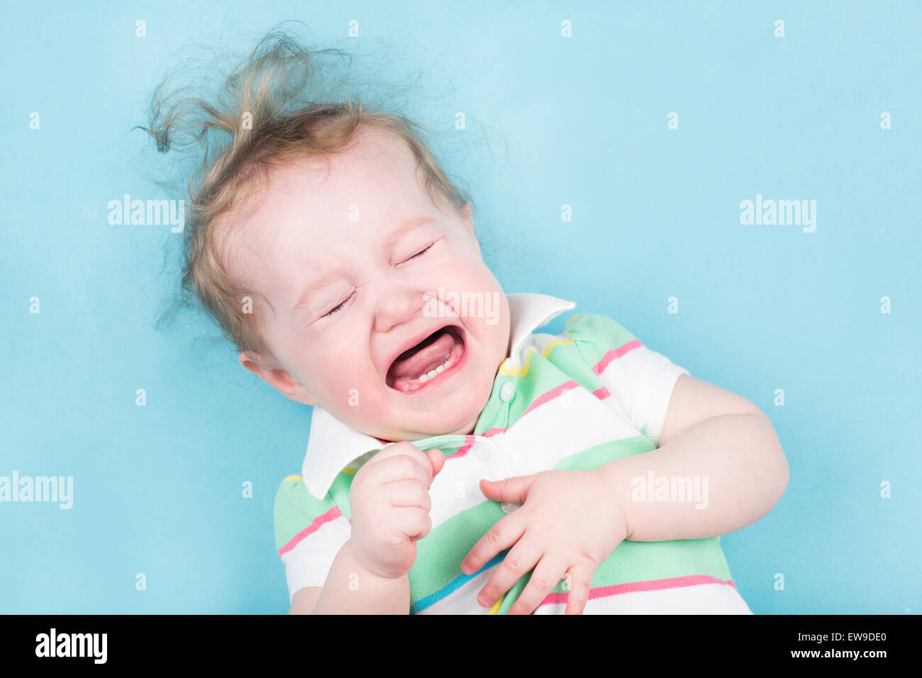 Sweet crying baby on a blue blanket Stock Photo - Alamy