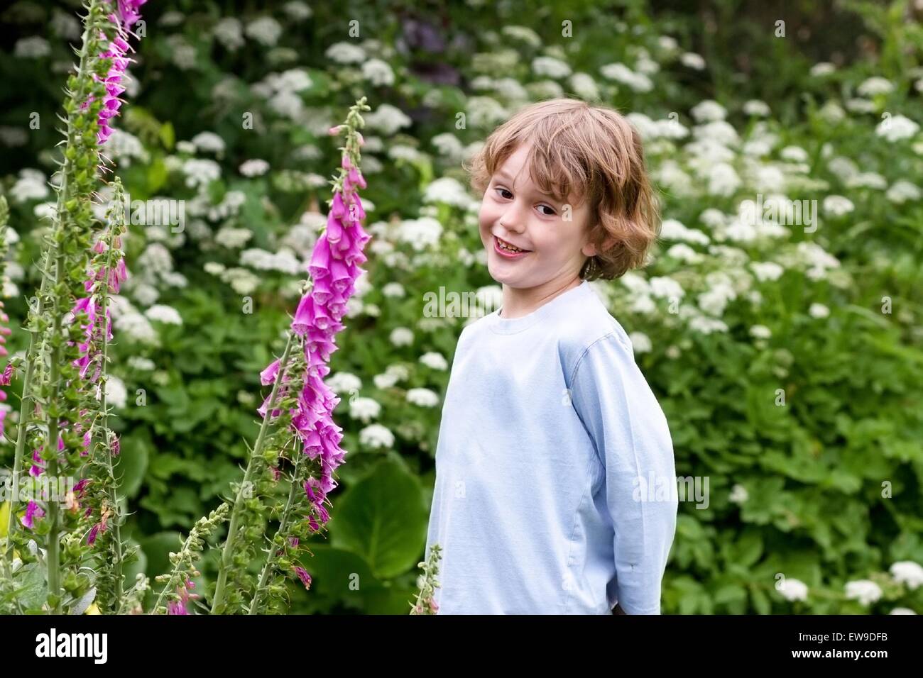 Cute little boy playing in the garden Stock Photo - Alamy