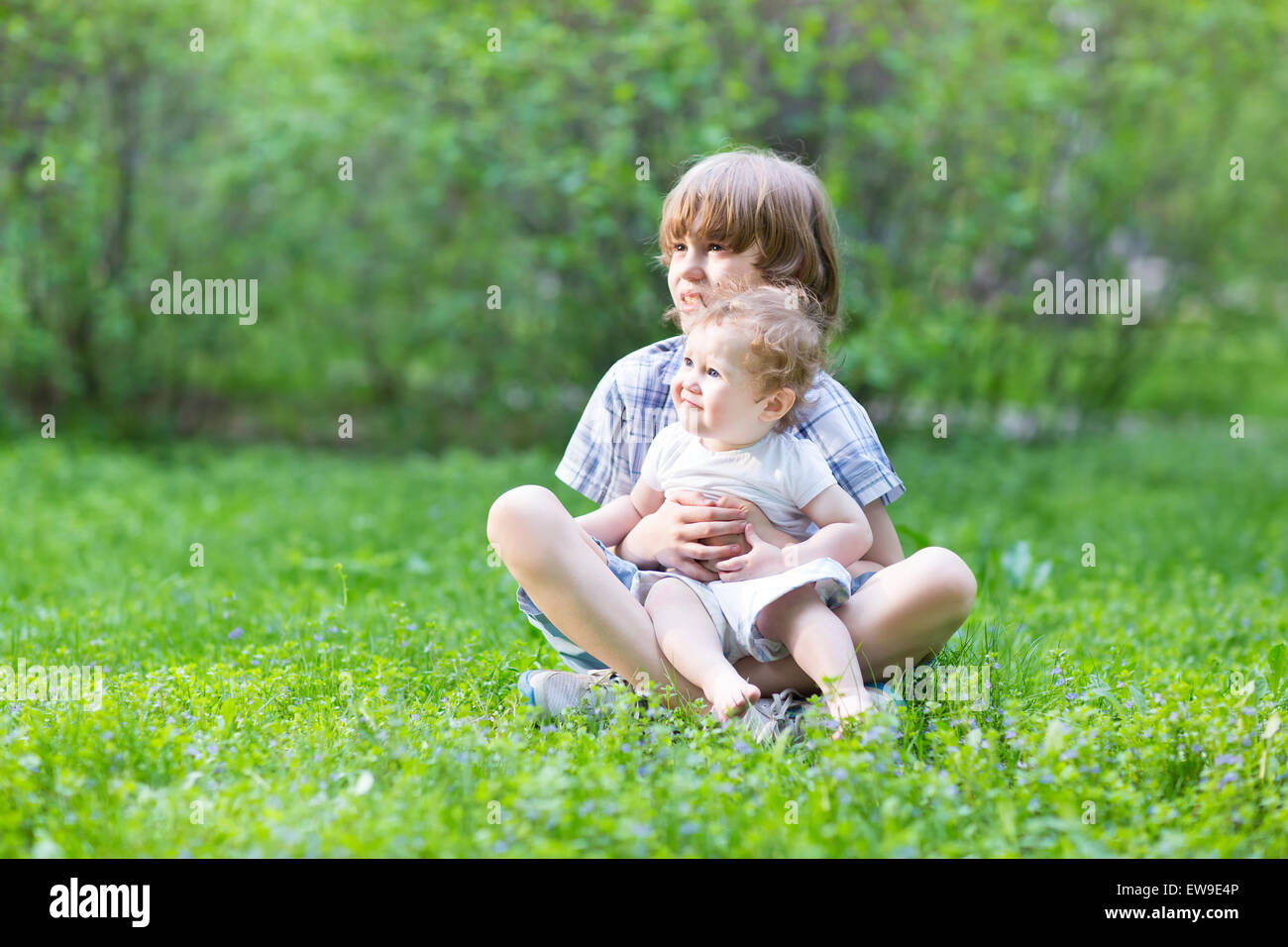 Two kids playing in the garden Stock Photo - Alamy