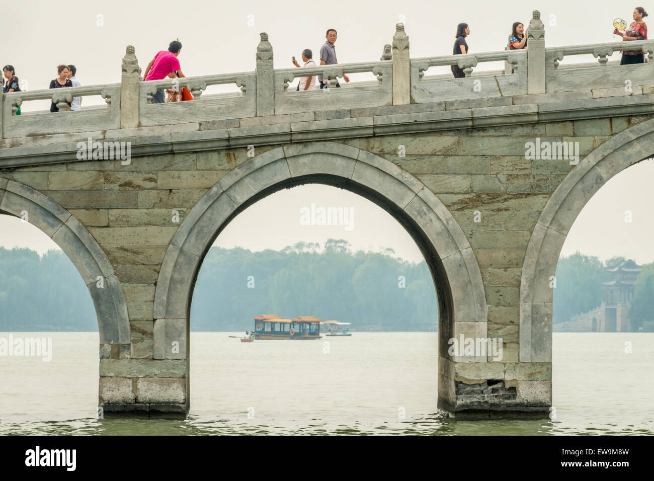 People walking over stone bridge with arches Stock Photo - Alamy