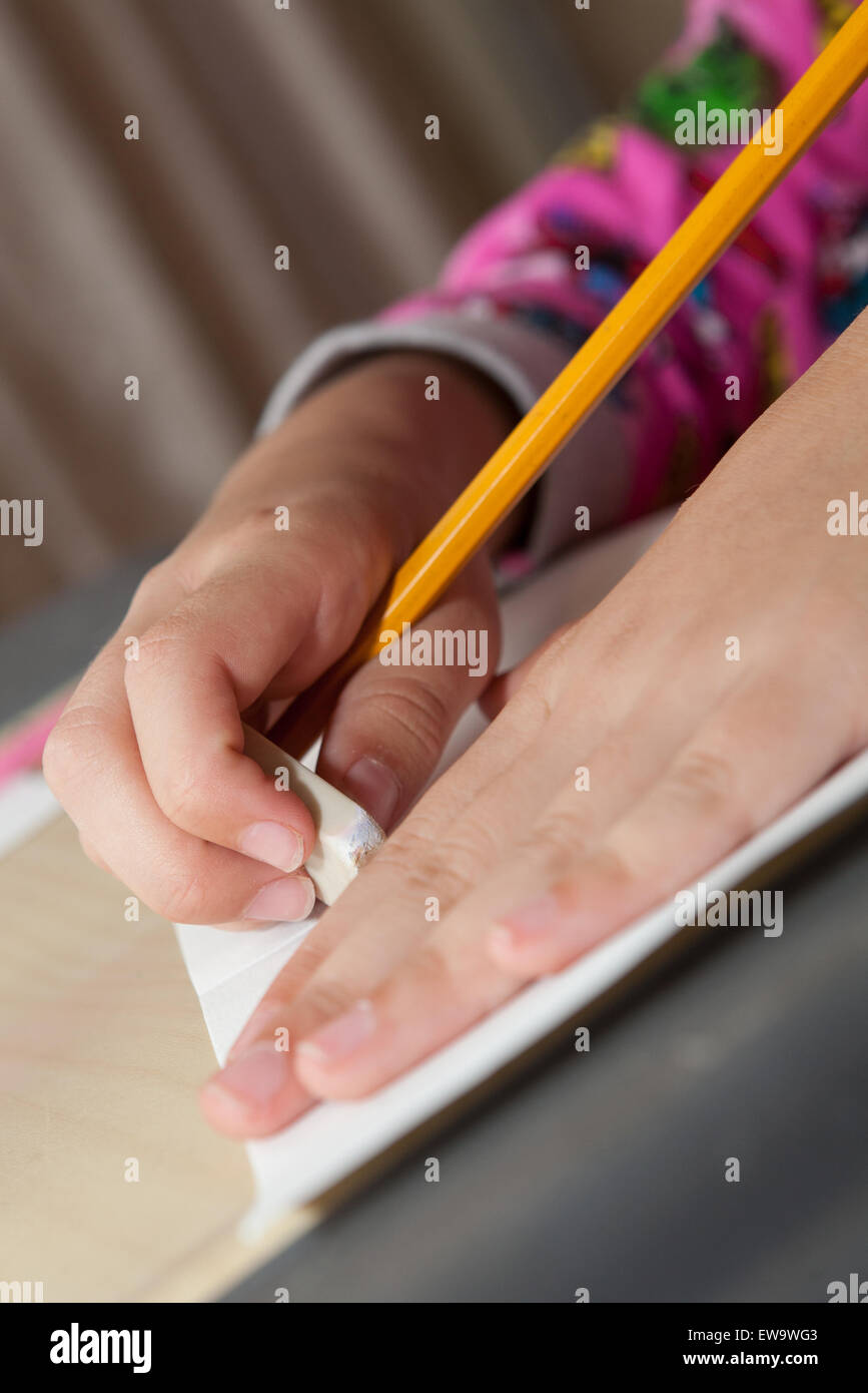 Child uses eraser on white paper drawing Stock Photo - Alamy
