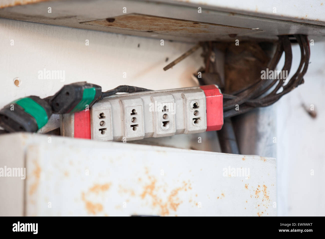 Rusty power strip resting on wall outlet Stock Photo - Alamy