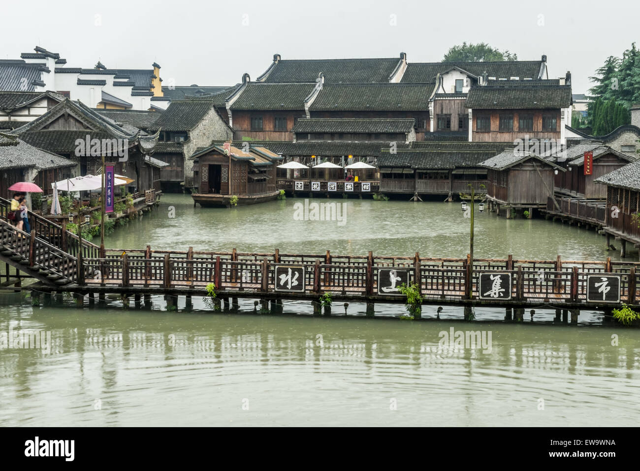 Flat wooden bridge crossing the canal surrounded by traditional Chinese ...
