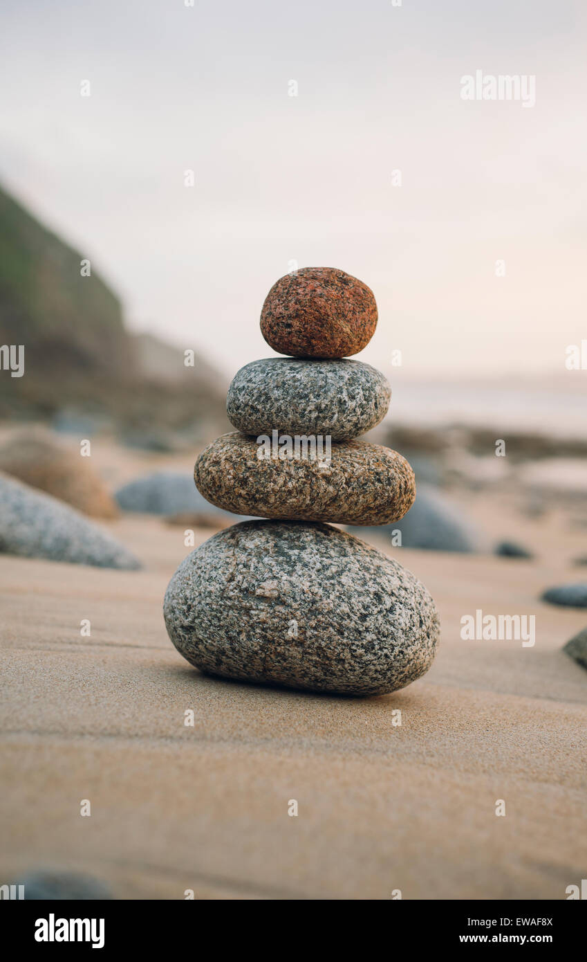 Four small rocks in balance on the beach Stock Photo - Alamy