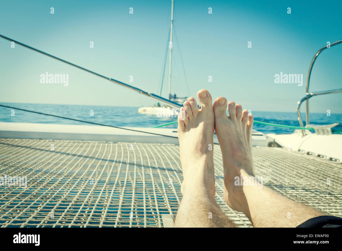 male feet relaxing on a catamaran sailboat Stock Photo - Alamy