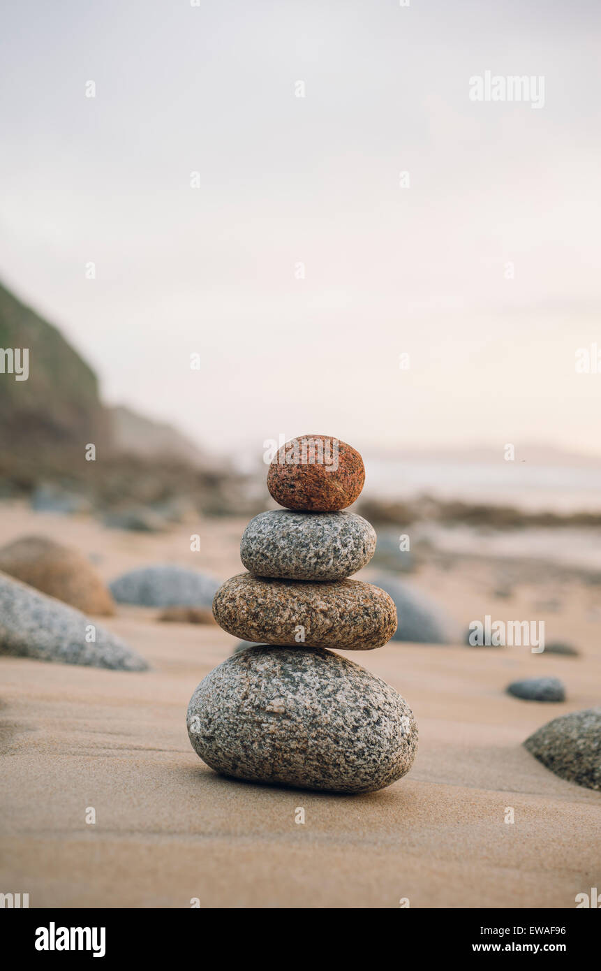 Four small rocks in balance on the beach Stock Photo - Alamy