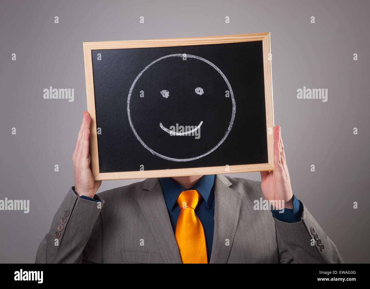 Businessman hiding his face with a white billboard with a smiley face ...