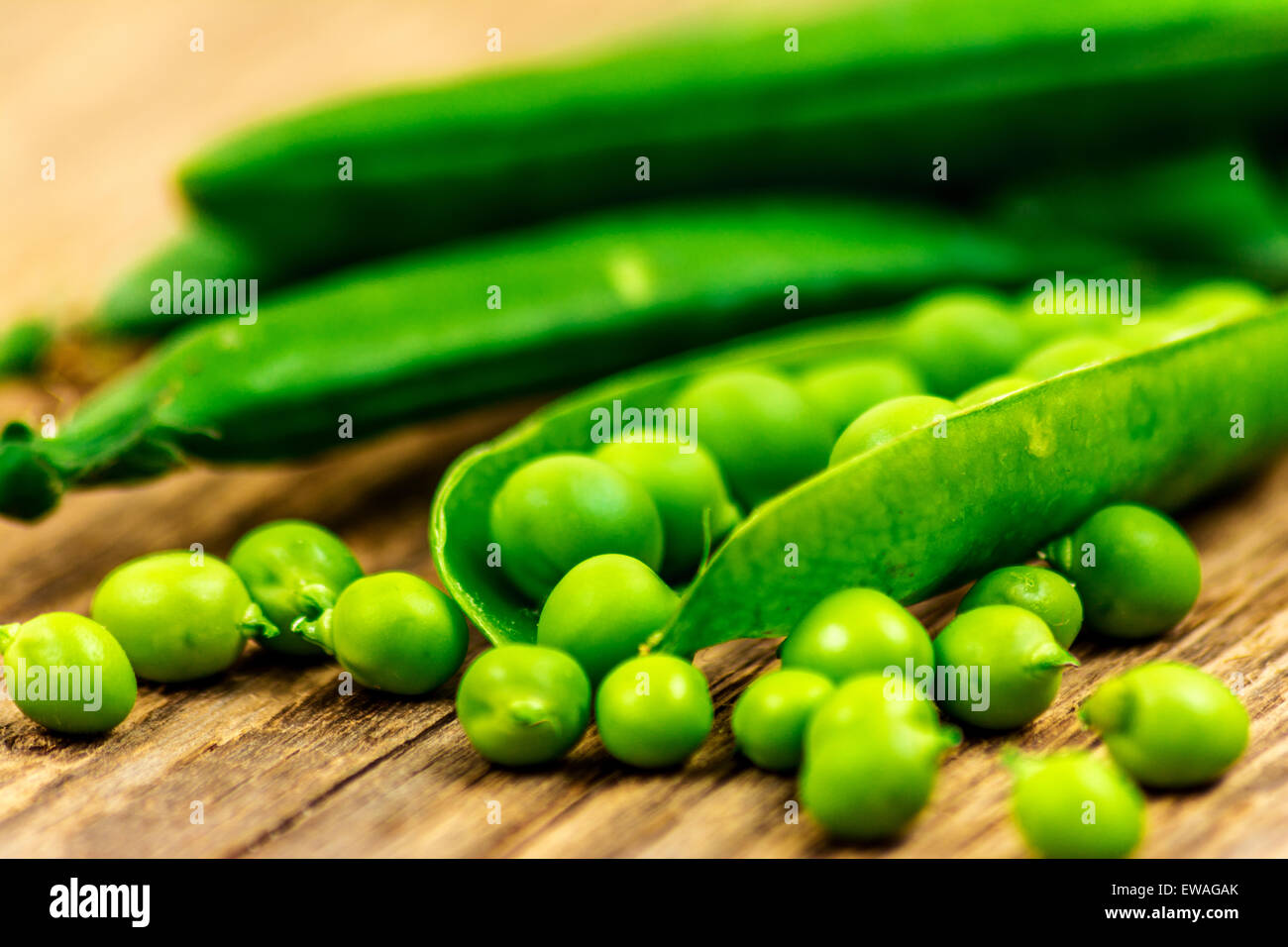 Many raw open pea on wood table Stock Photo - Alamy