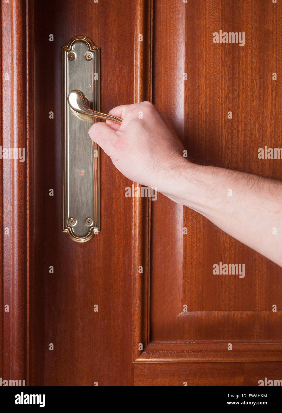 Hand gripping the handle of a door inside home Stock Photo - Alamy