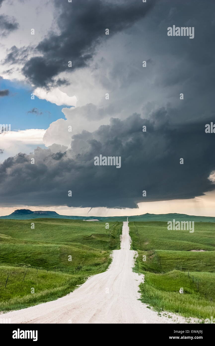 Supercell storm with small tornado moves across the badlands area of ...