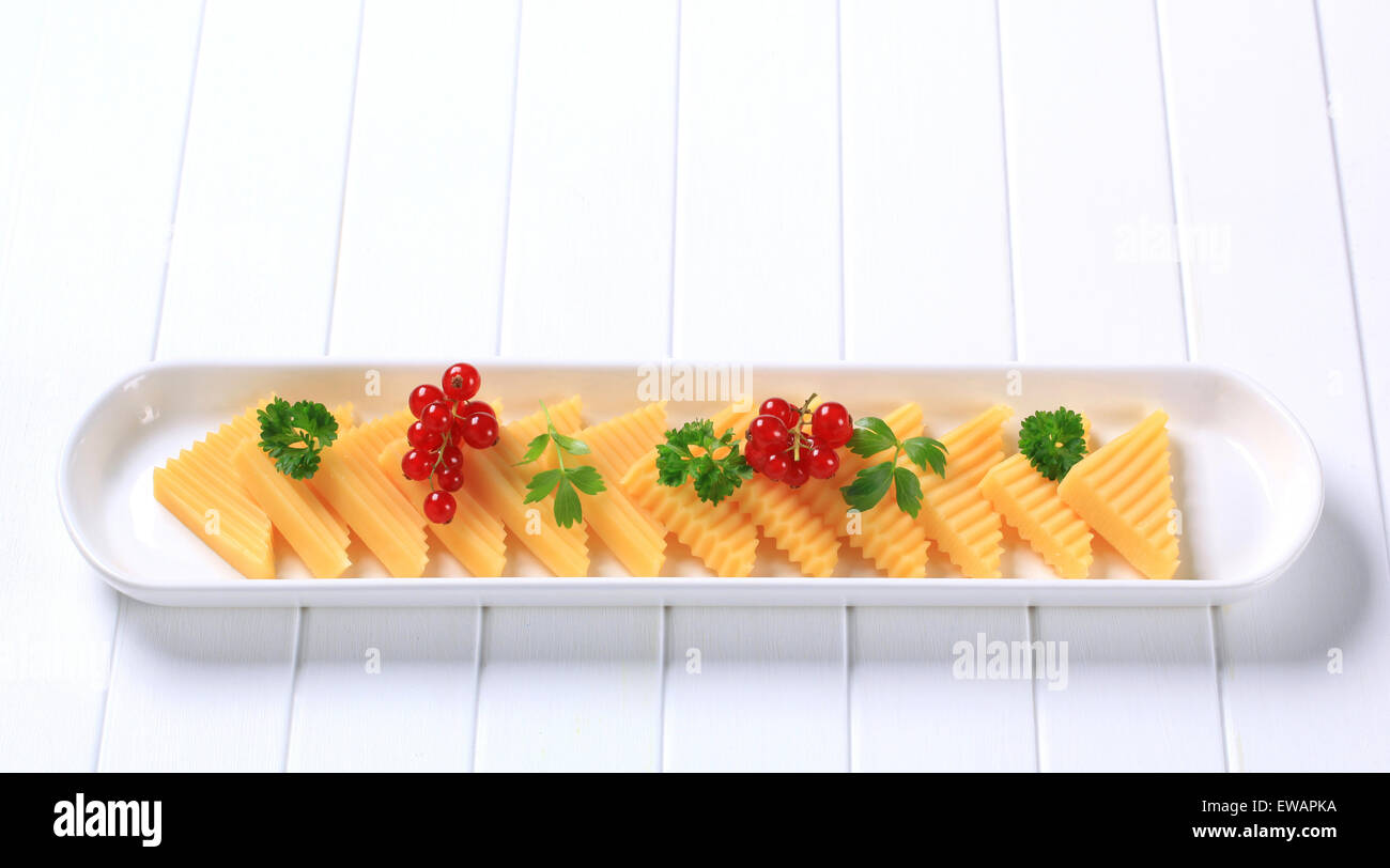 Hard cheese cut into triangles Stock Photo - Alamy