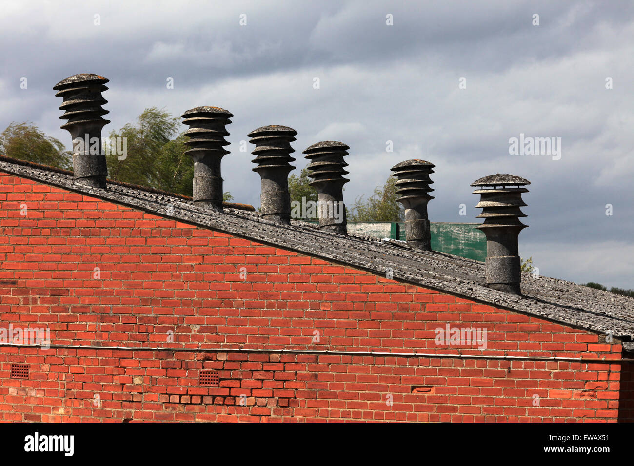 Old factory with asbestos chimney pots/flues visible above the roof ...