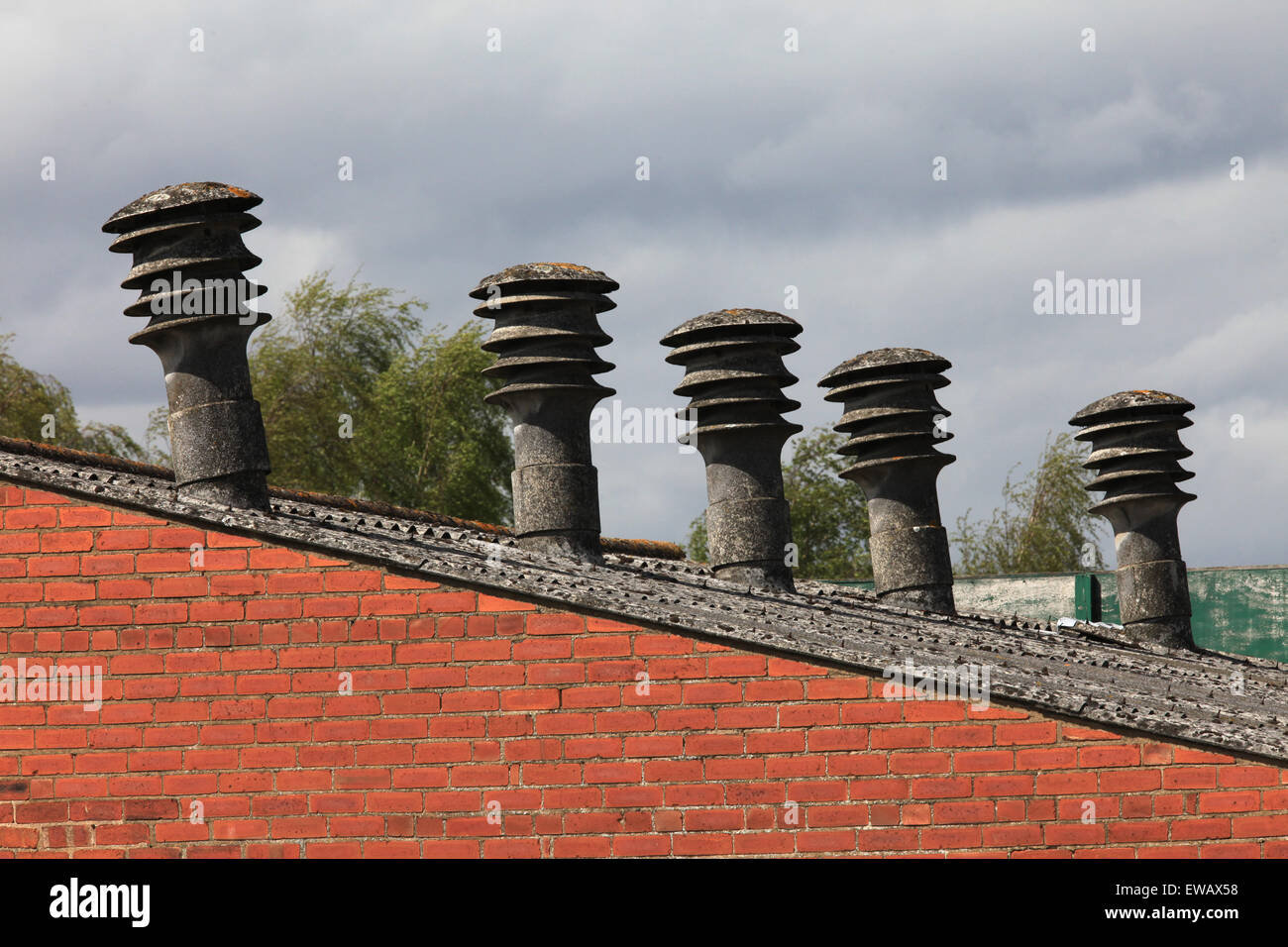 Old factory with asbestos chimney pots/flues visible above the roof ...