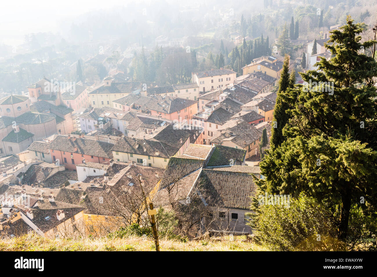 Tile roofs of Italian country village in a winter foggy and sunny day ...