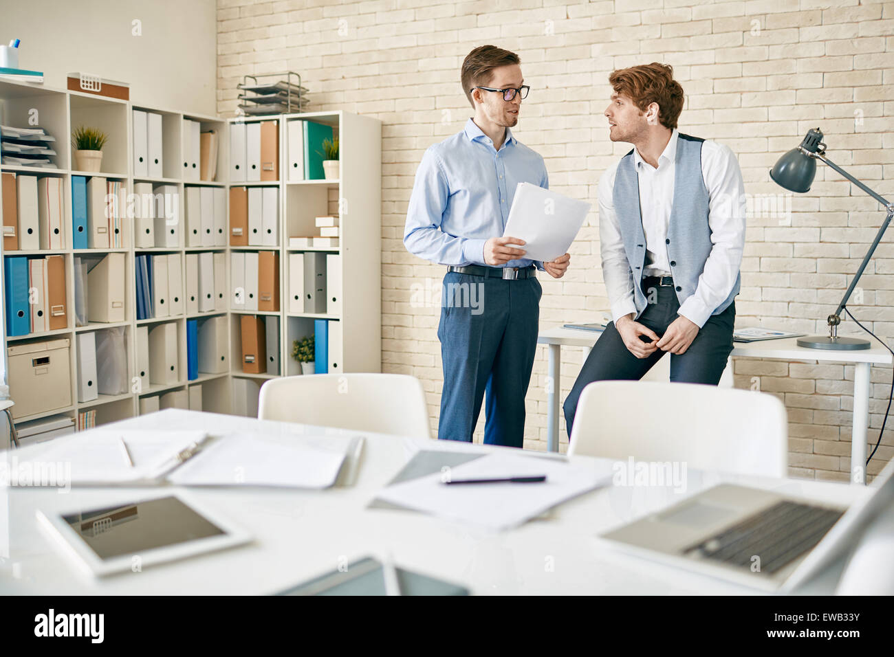 Two male employees discussing plans in office Stock Photo - Alamy