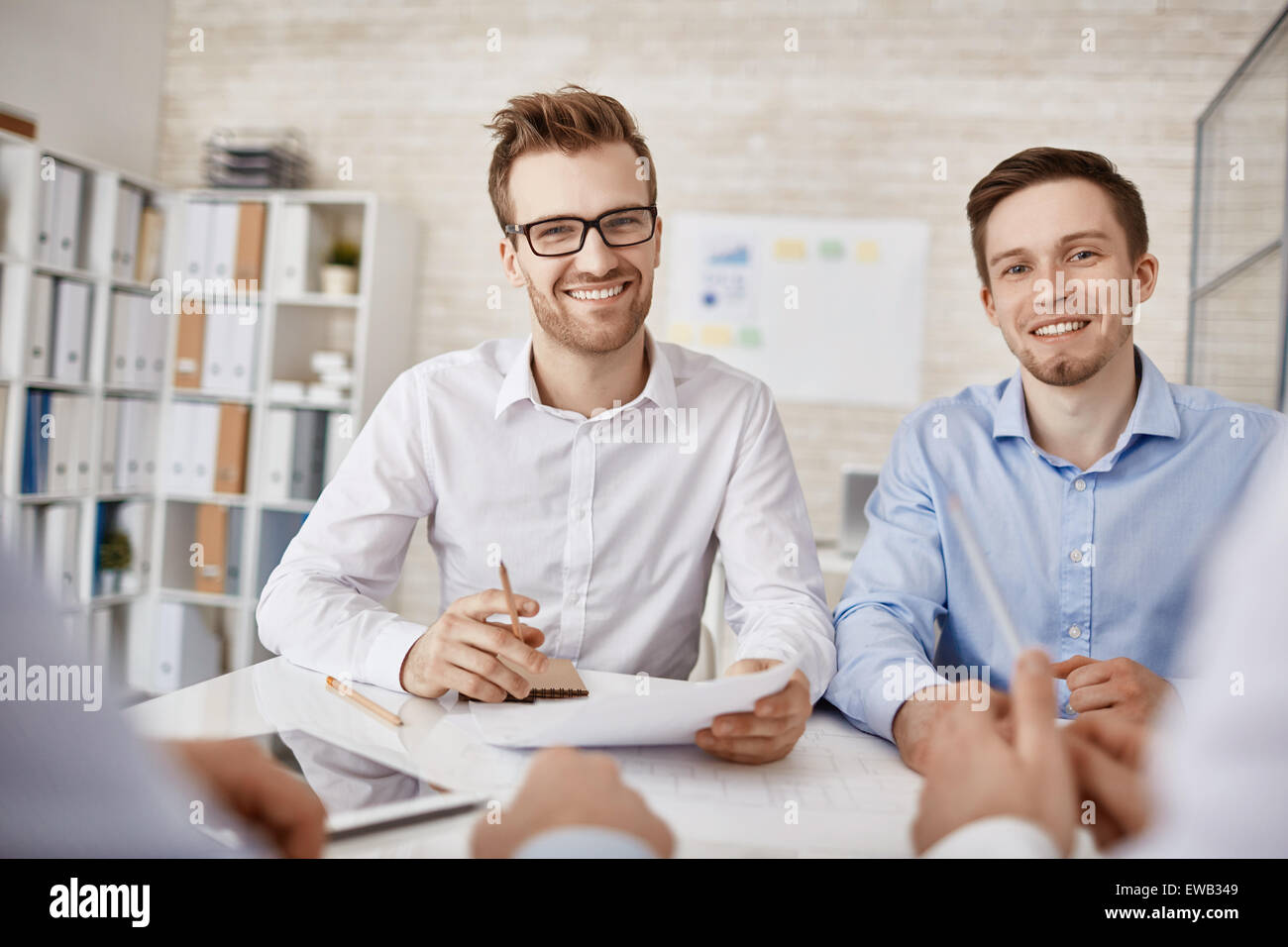 Two successful businessmen looking at camera at workplace in office ...