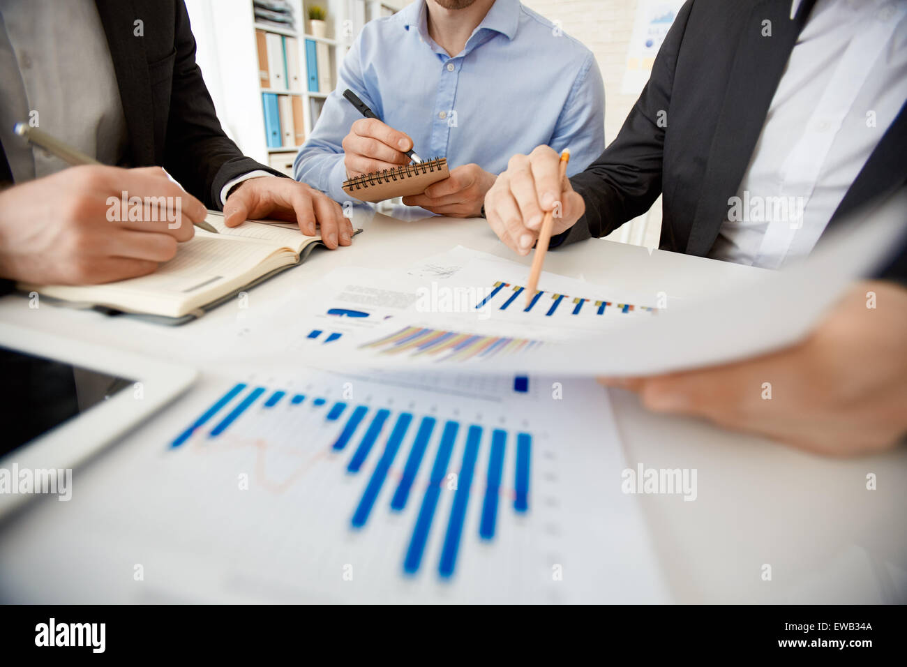 Businessman pointing at paper with chart while explaining it to ...