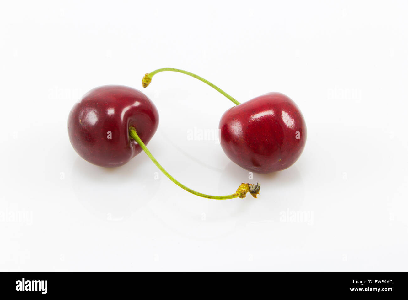Two red cherry isolated on white background Stock Photo - Alamy