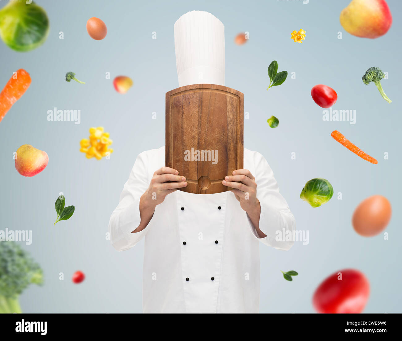 male chef cook covering face with cutting board Stock Photo - Alamy