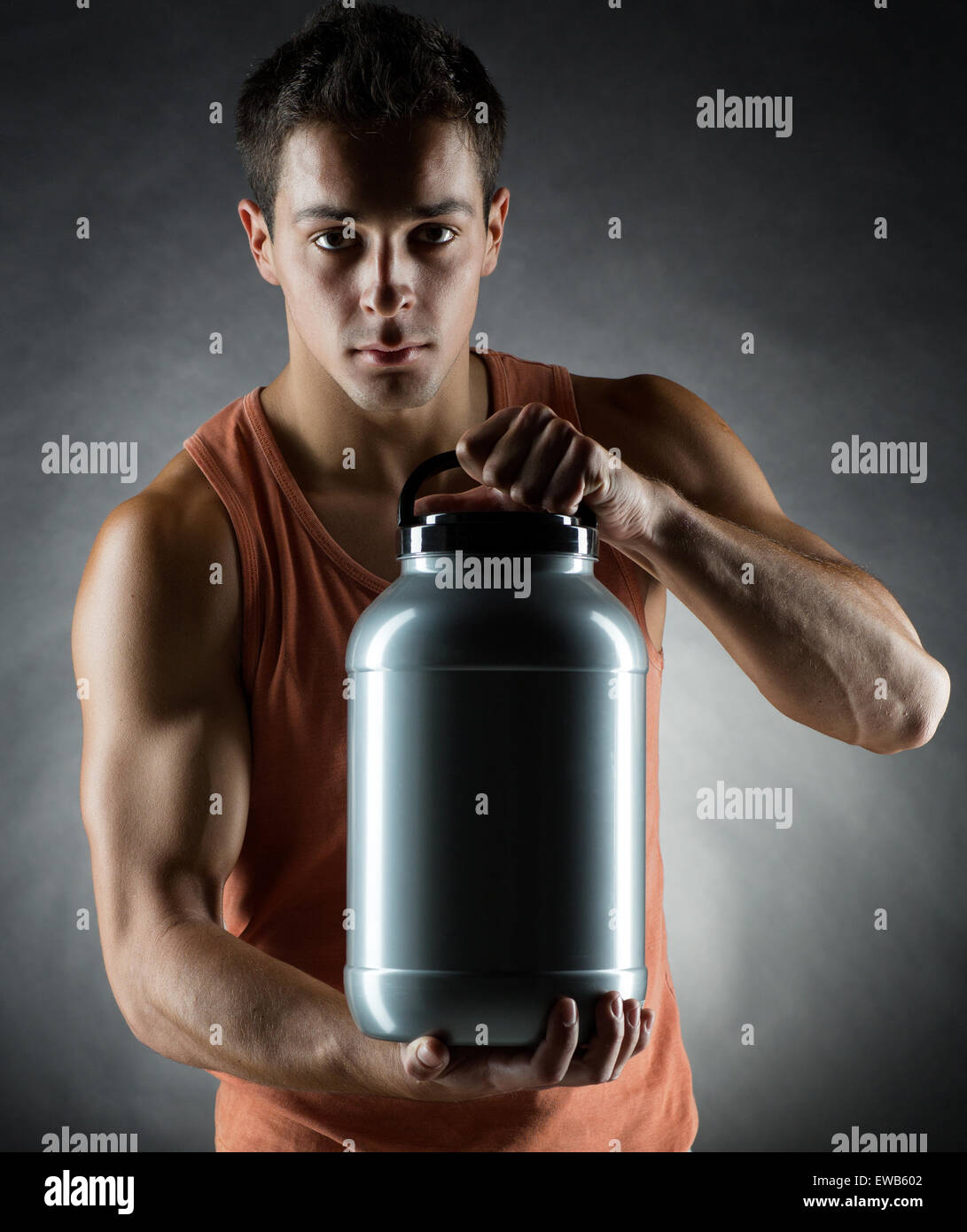 young male bodybuilder holding jar with protein Stock Photo - Alamy