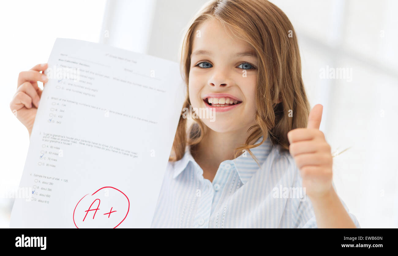 smiling little student girl with test and A grade Stock Photo - Alamy