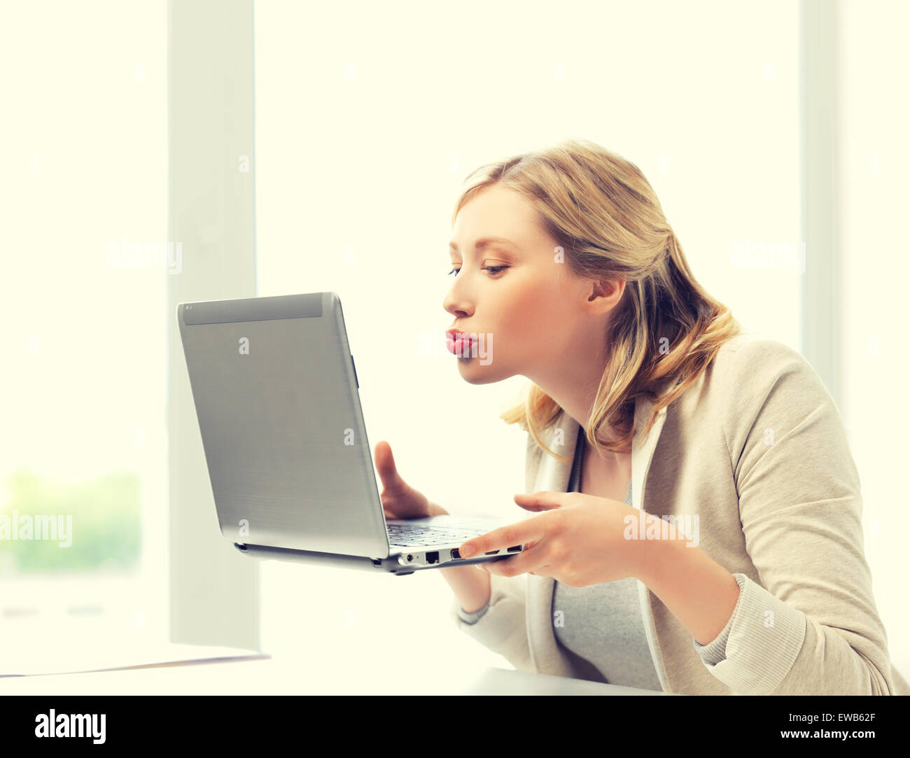 woman sending kisses with laptop computer Stock Photo - Alamy