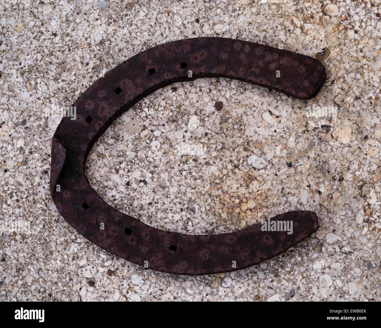 Old iron horseshoe on concrete path background Stock Photo - Alamy