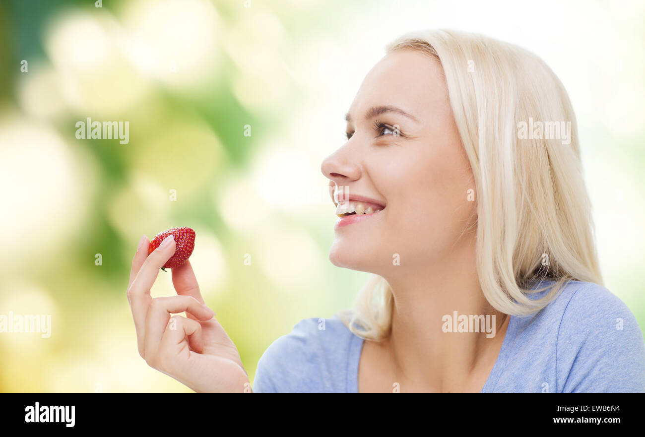 happy woman eating strawberry Stock Photo - Alamy