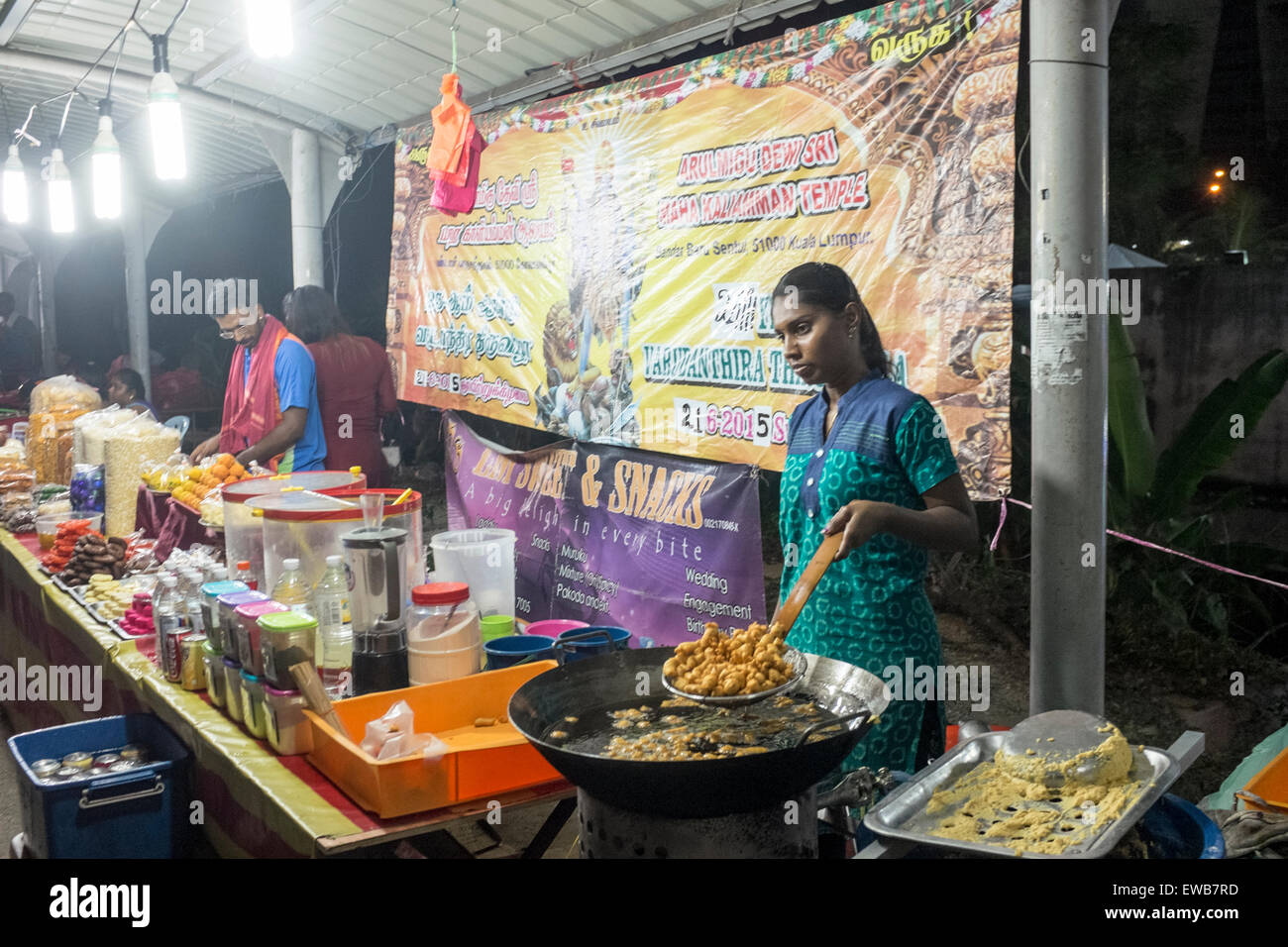 A vendor prepares fried snacks at a stall at a market in Bandar Baru ...