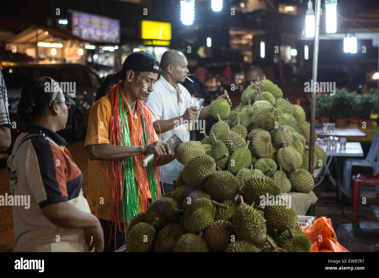 A man prepares a Durian for a customer at Chow Kit night market in ...