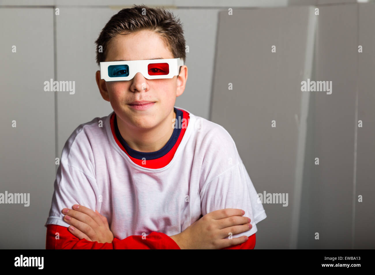A Caucasian boy wears a pair of 3D Cinema paper eyeglasses with red and ...