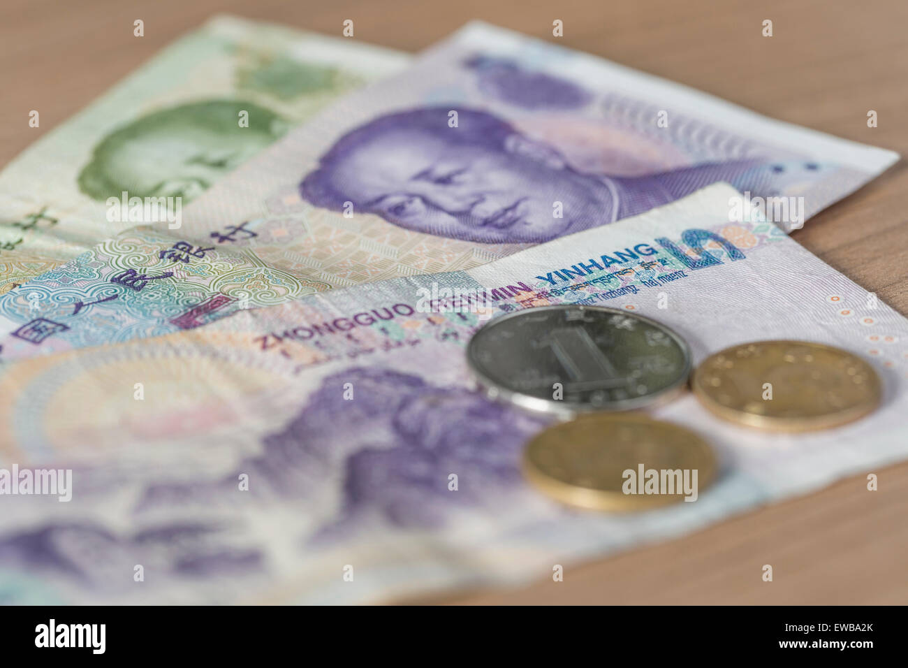 Chinese Renminbi (also called Yuan) banknotes and coins on a wooden ...