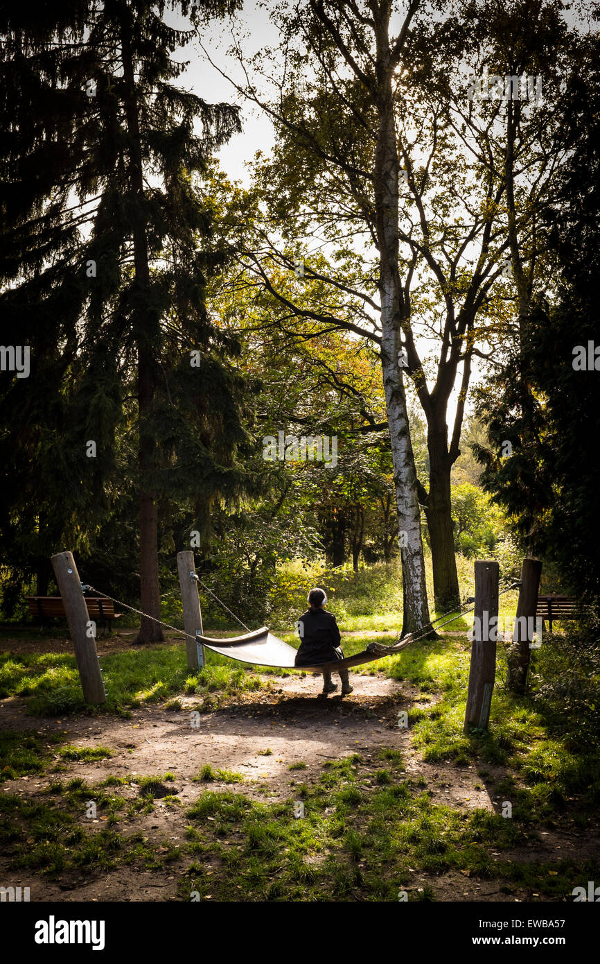 Woman sitting in park Stock Photo - Alamy