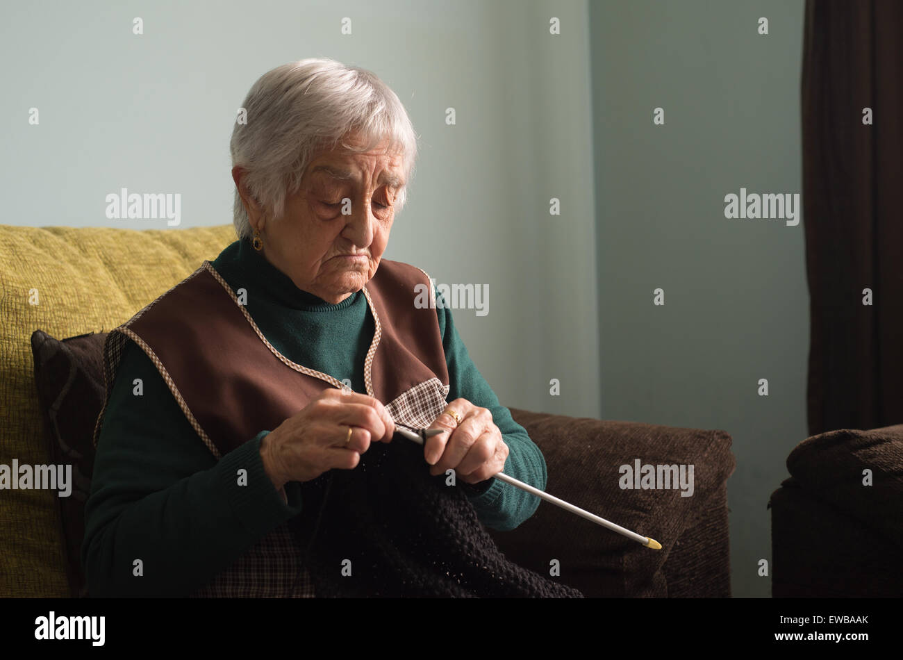 Elderly woman knitting at home. Woman is focus in her activity Stock ...