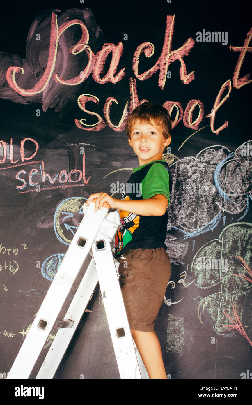 little cute boy at blackboard in classroom, back to school Stock Photo ...