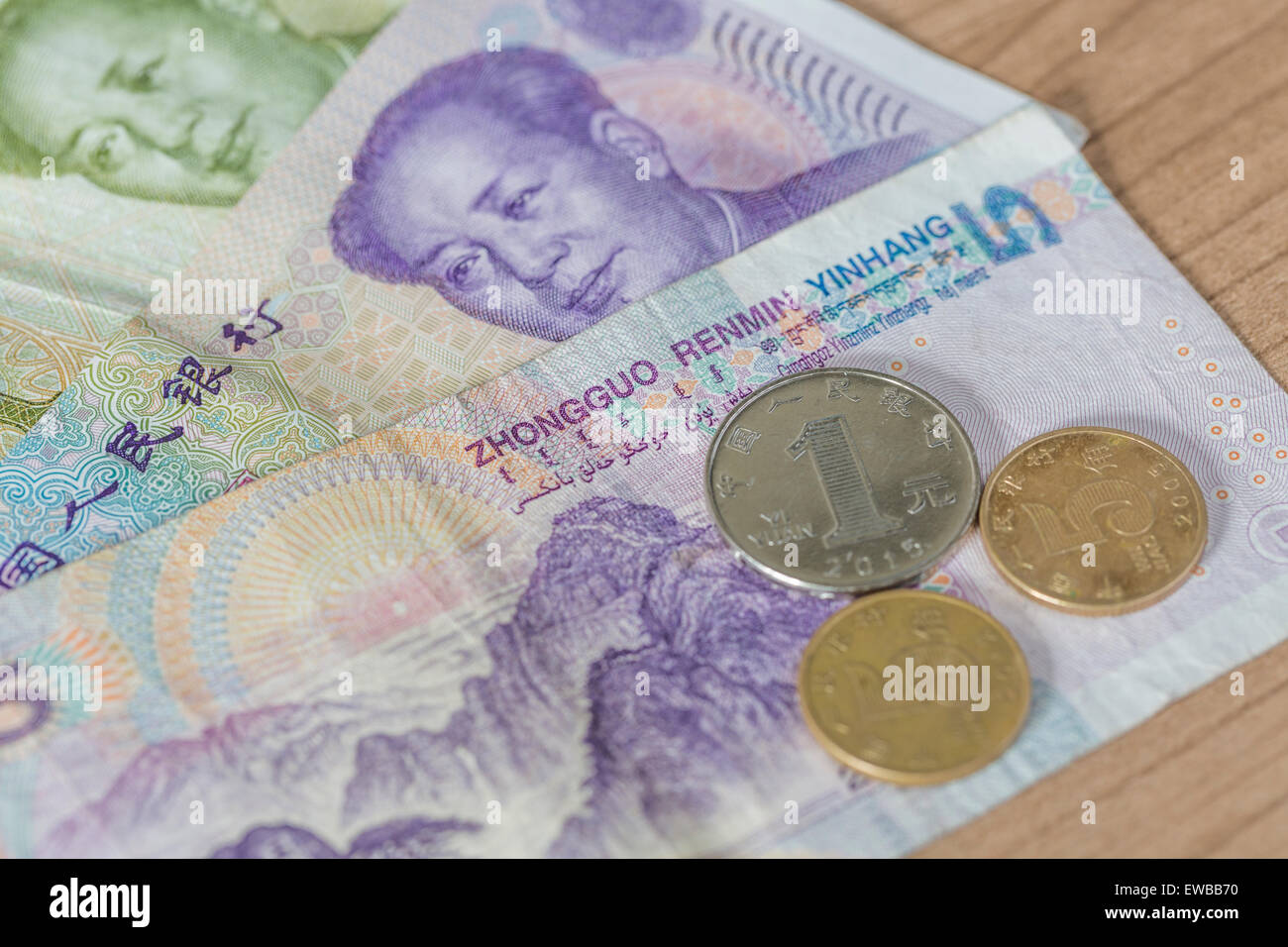 Chinese Renminbi (also called Yuan) banknotes and coins on a wooden ...