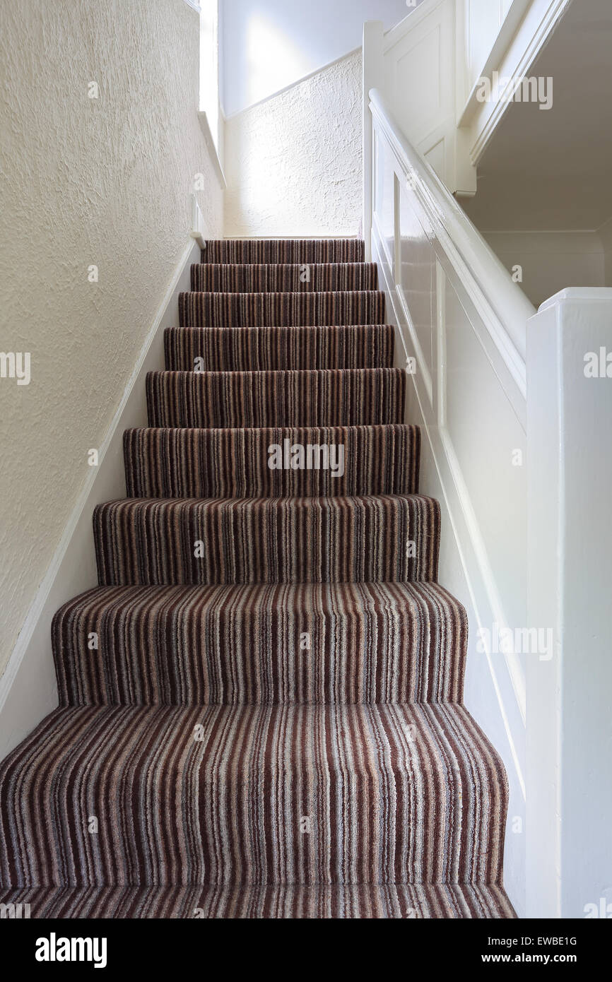 Stairs with brown striped carpet Stock Photo - Alamy